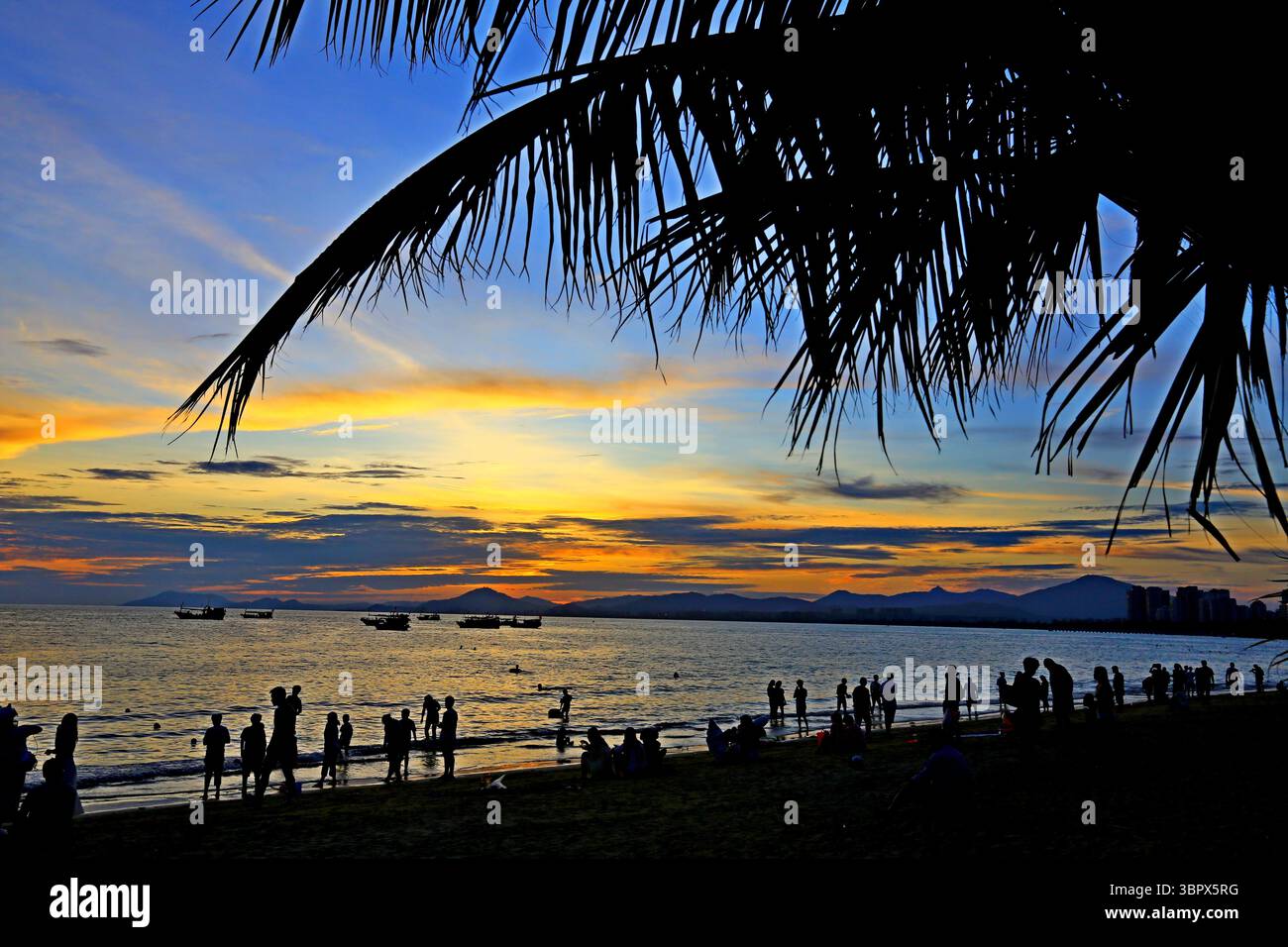Tourists play at the seaside in Sanya City, southernmost China's Hainan ...