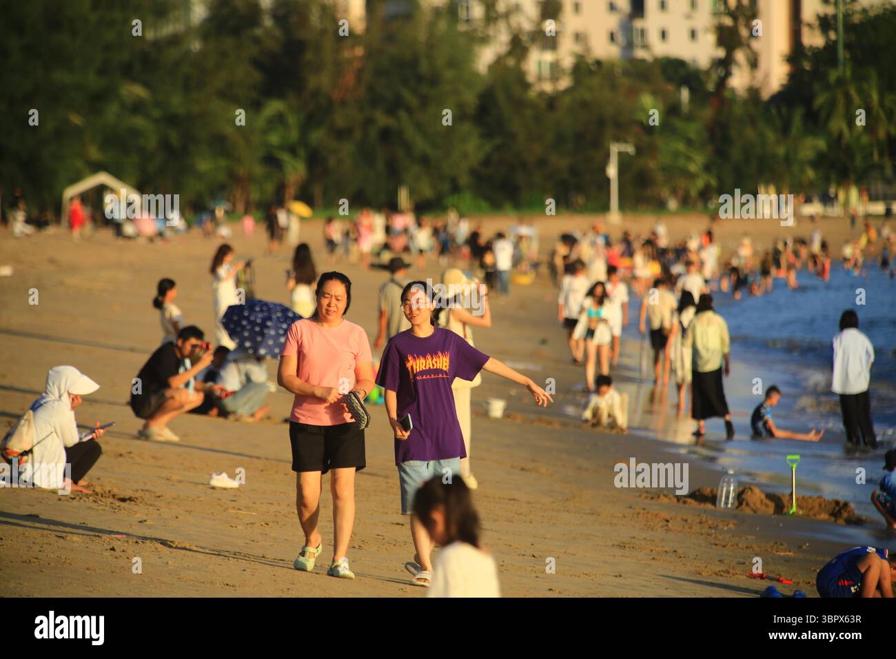 Tourists play at the seaside in Sanya City, southernmost China's Hainan ...