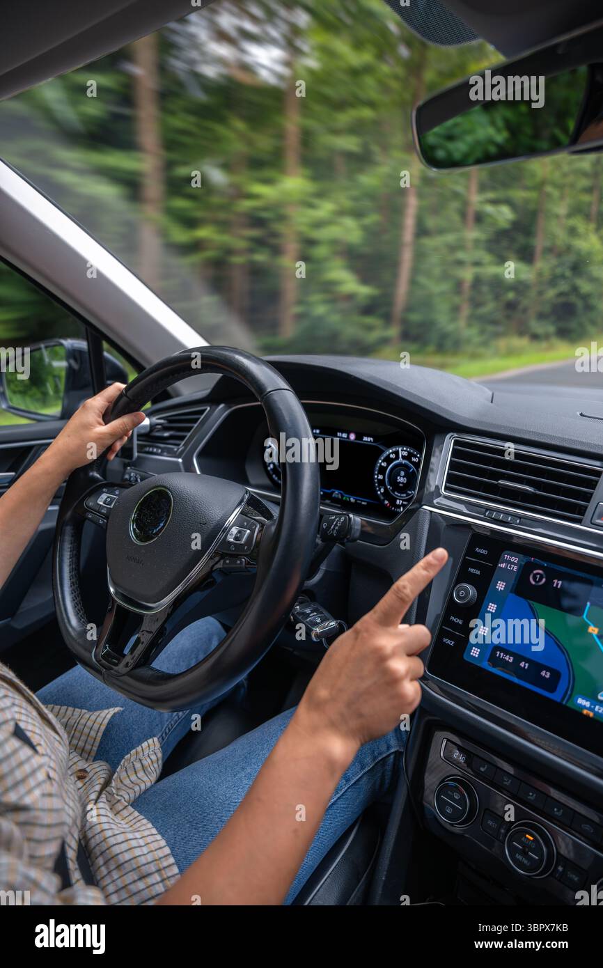 Woman driving car. Touching navigation screen. Forest road motion Stock ...