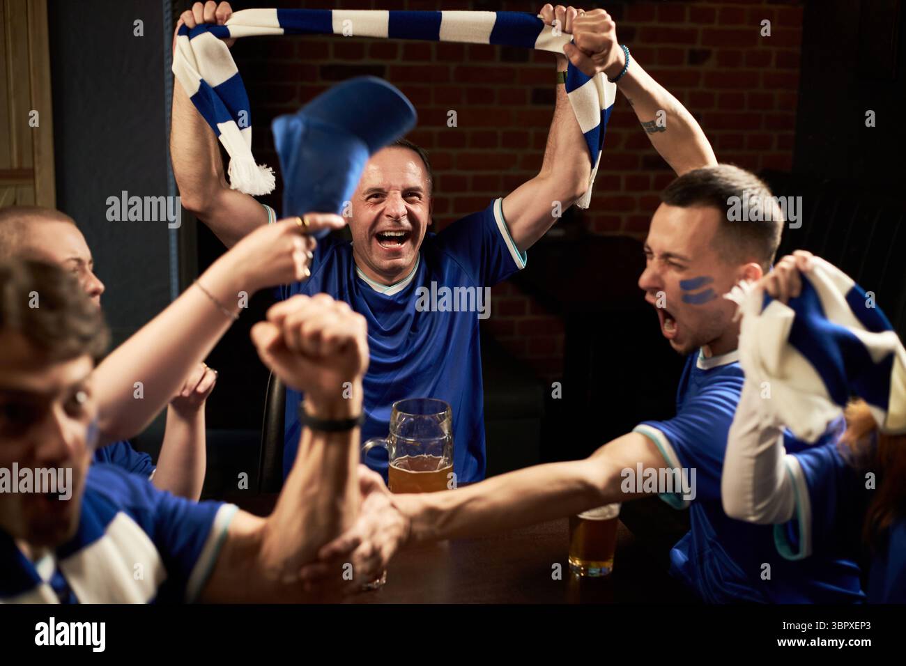 Group of Caucasian young men celebrating soccer match victory in bar ...