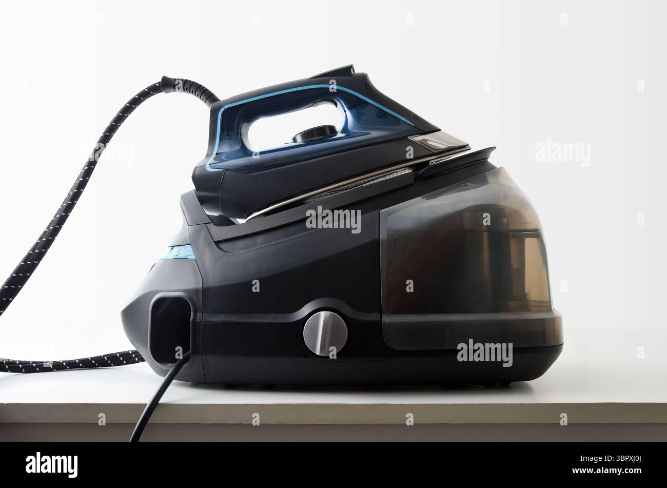Domestic continuous steam ironing center with water tank on a wooden ...