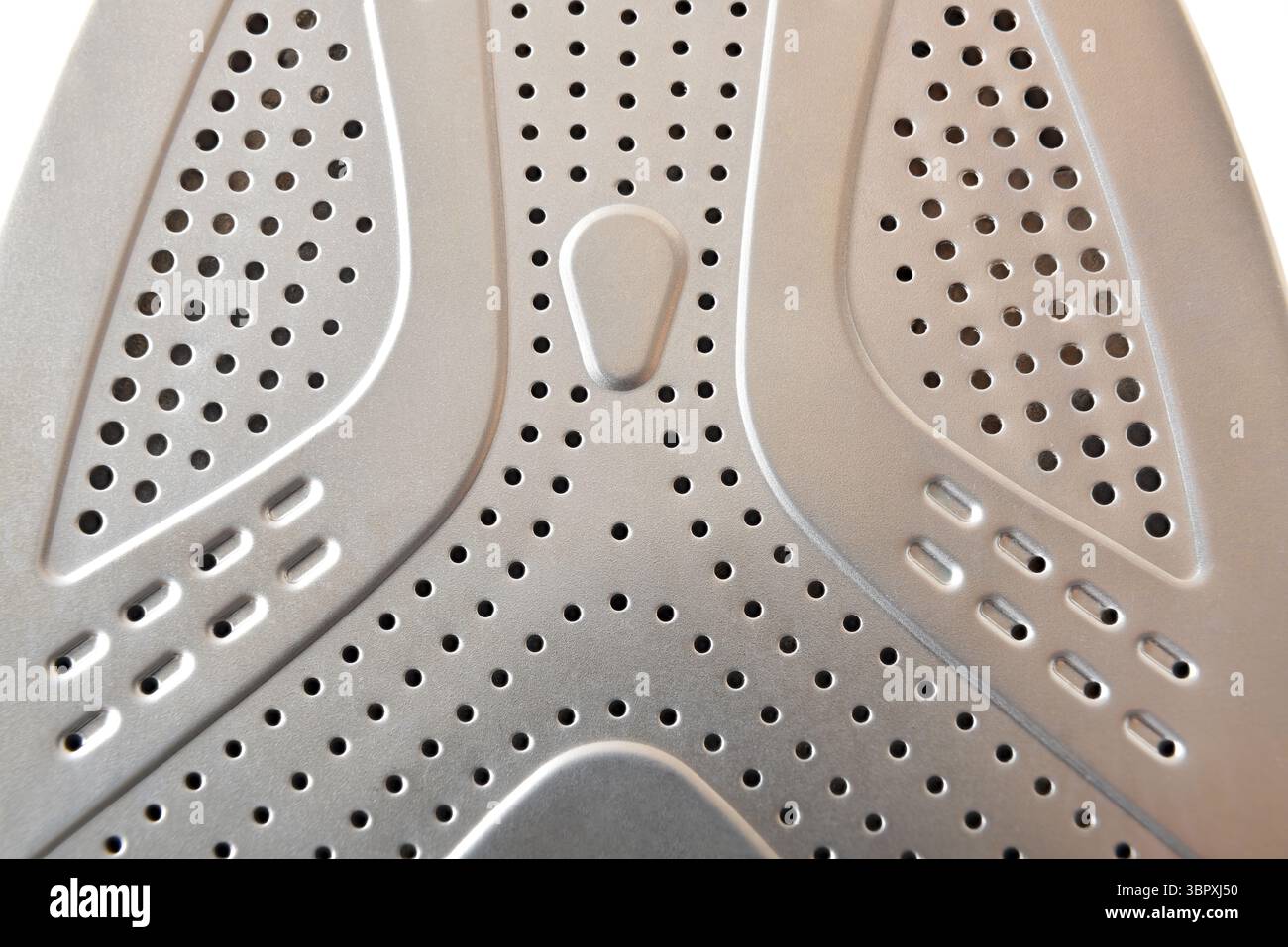 Detail of metal soleplate with symmetrical steam outlet holes of a ...