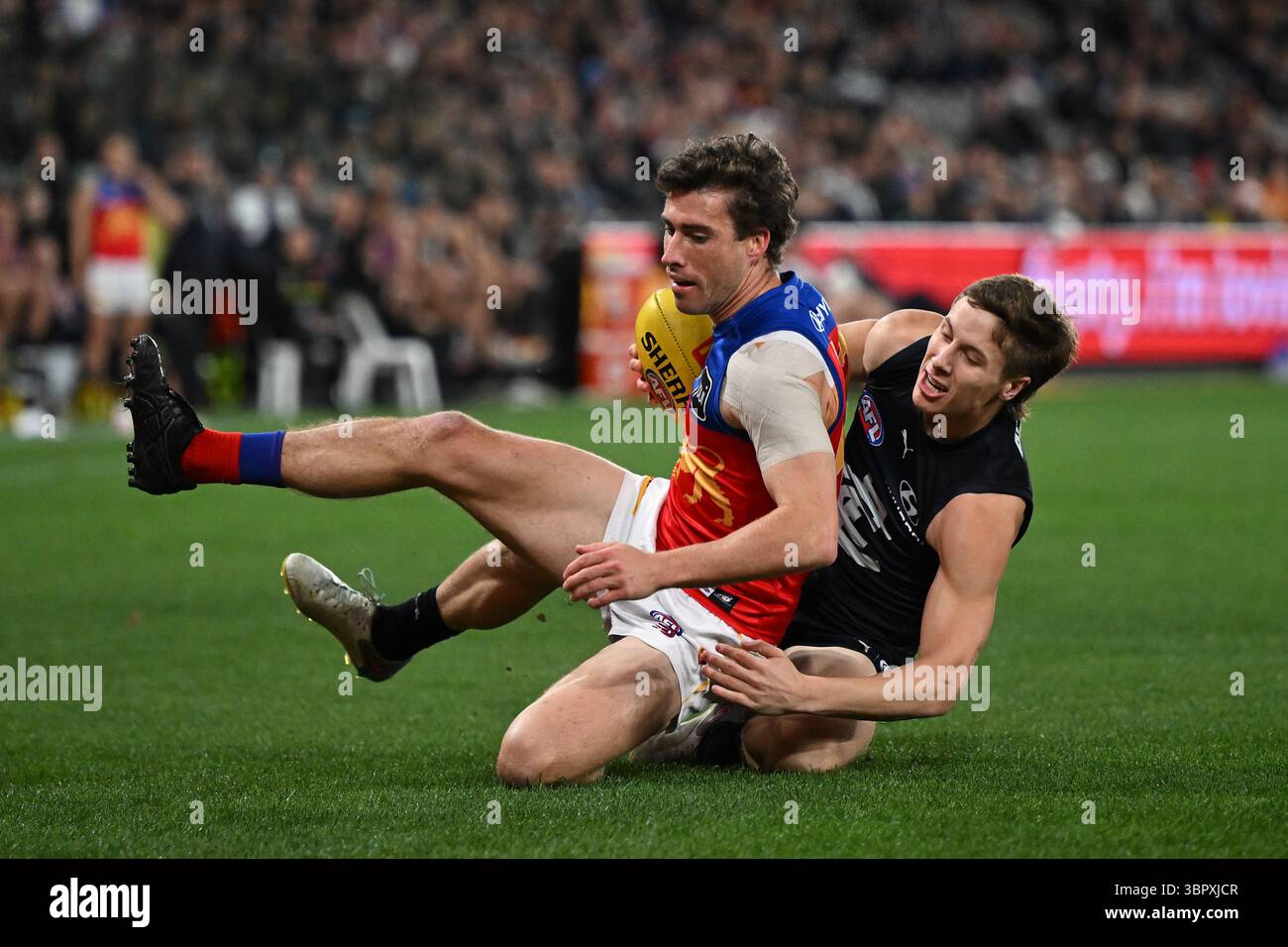 Noah Answerth of the Lions (left) is tackled by Lachie Fogarty of ...