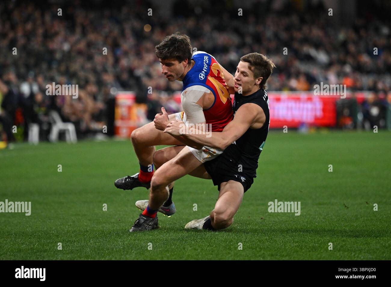 Noah Answerth of the Lions (left) is tackled by Lachie Fogarty of ...