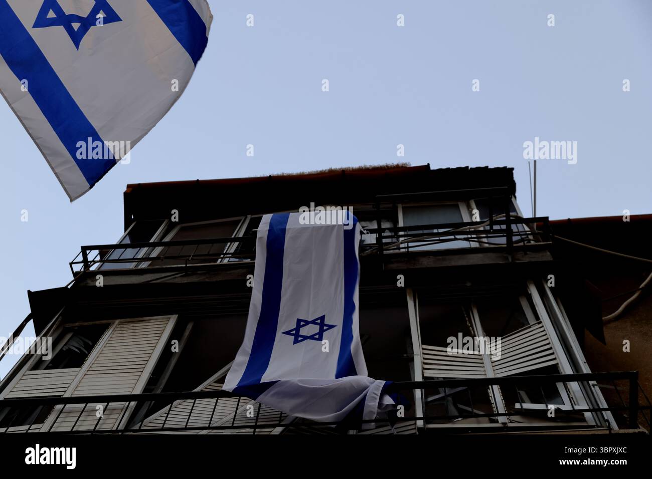 An Israeli flag draped over a damaged Ramat Gan building stands as a ...
