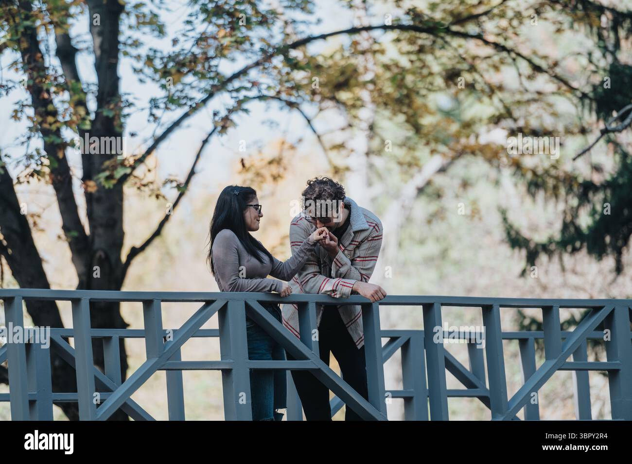 Romantic couple enjoys a tender moment on a scenic bridge Stock Photo ...