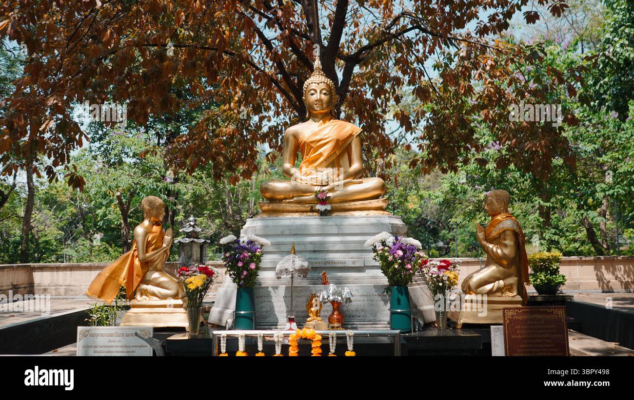Serene golden buddha statue meditating, flanked by praying monks inside ...