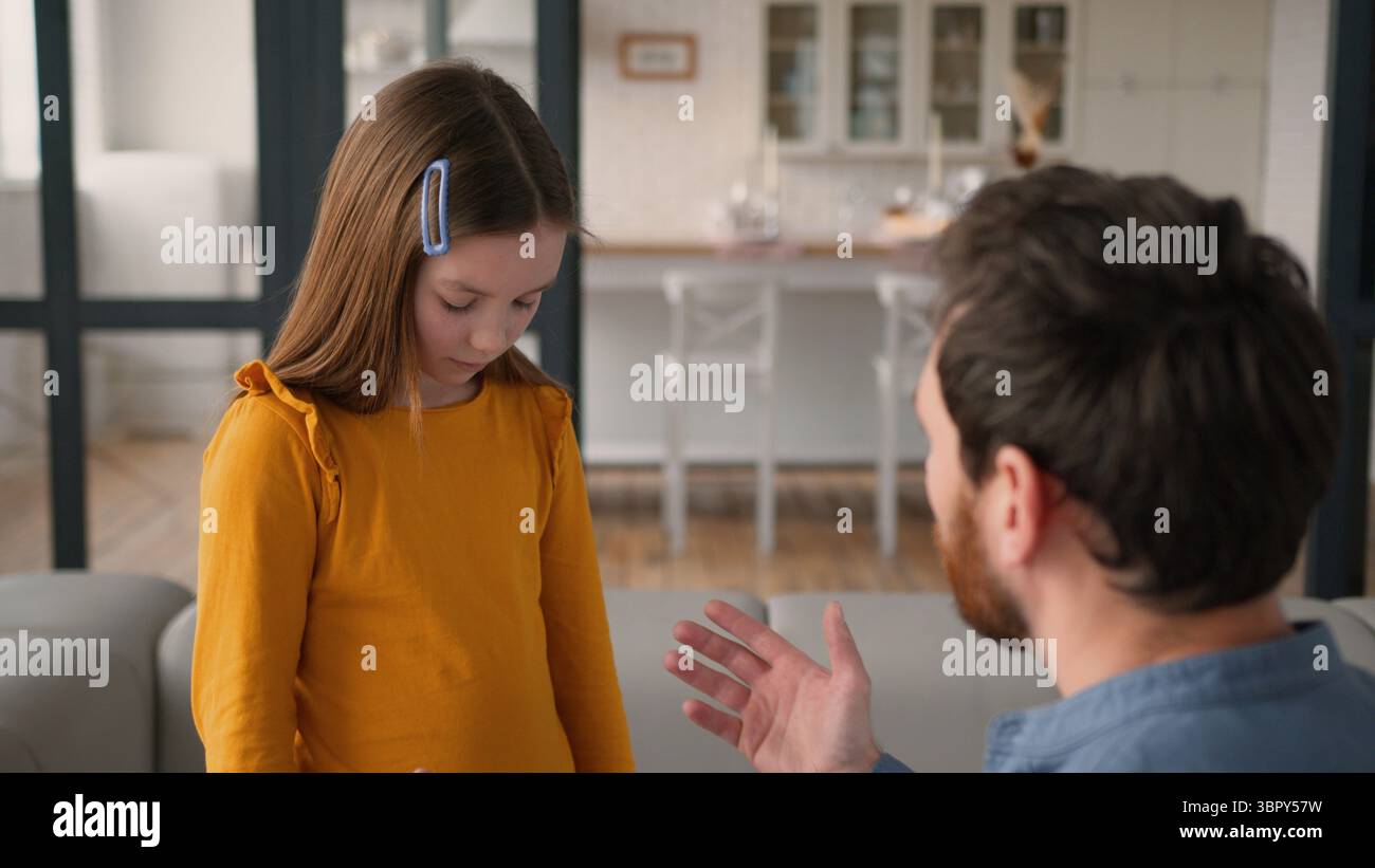 Irritated angry Caucasian dad male man speaking shout on ashamed daughter little child kid girl ...
