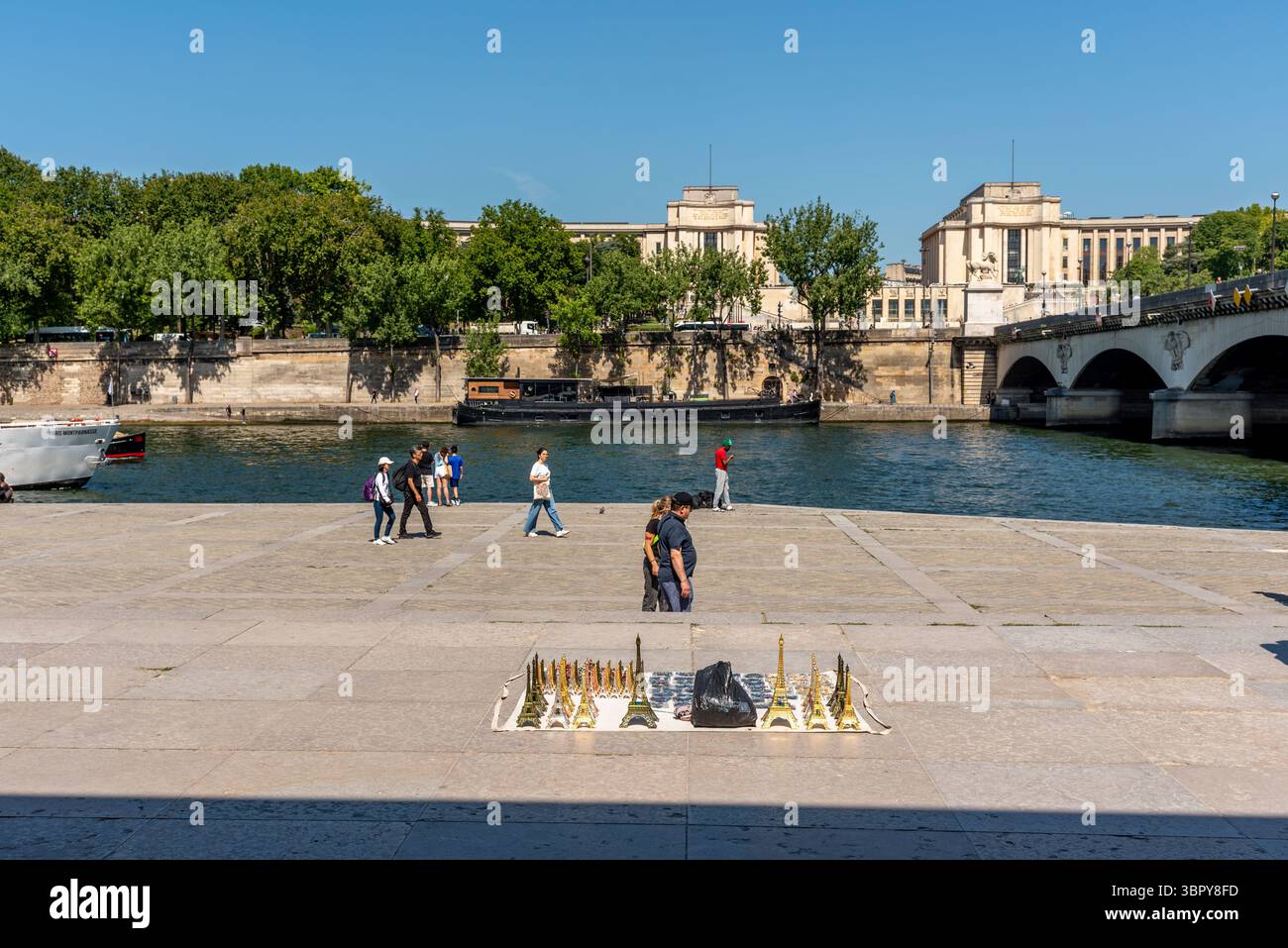 Little Eiffel towers standing on a sheet on the left bank of the Seine ...