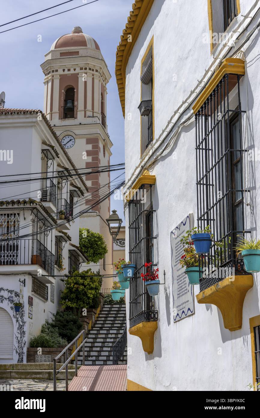 Bell tower -Torre del Reloj with white house walls on whose walls hang ...