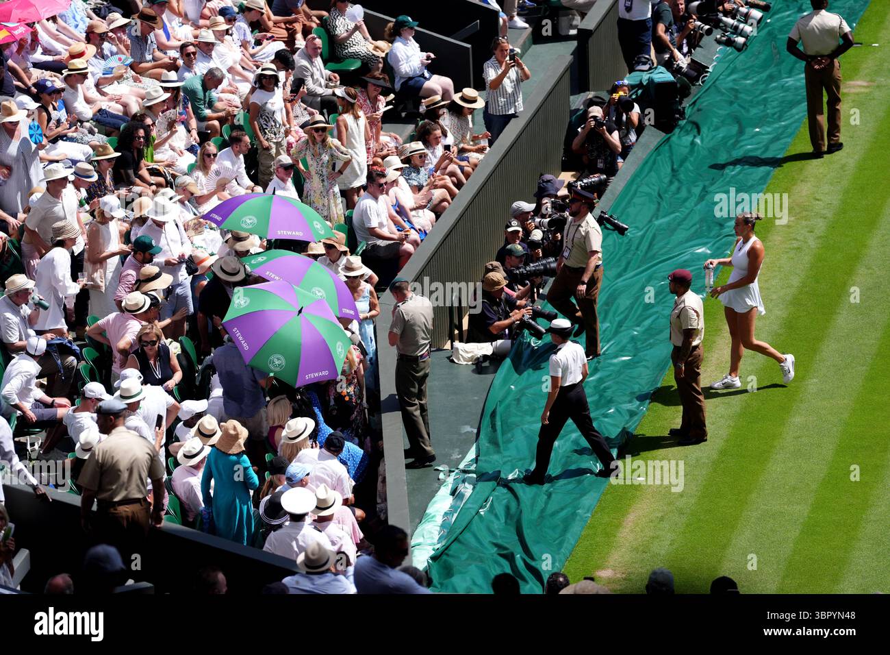 Stewards attend to a spectator in the crowd who is struggling with the ...
