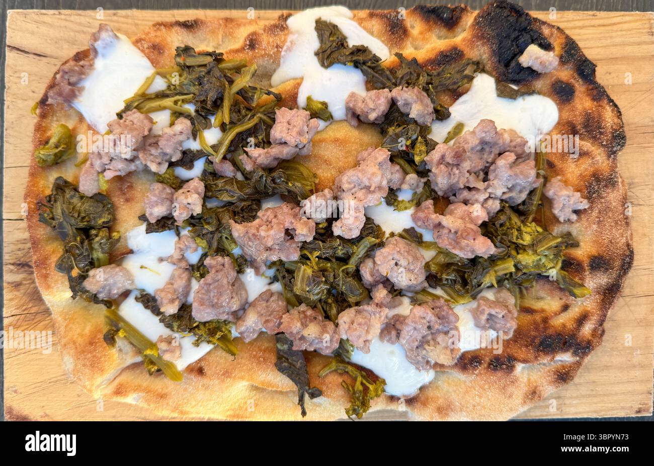 Roman-style flatbread with sausage and sautéed broccoli rabe Stock ...