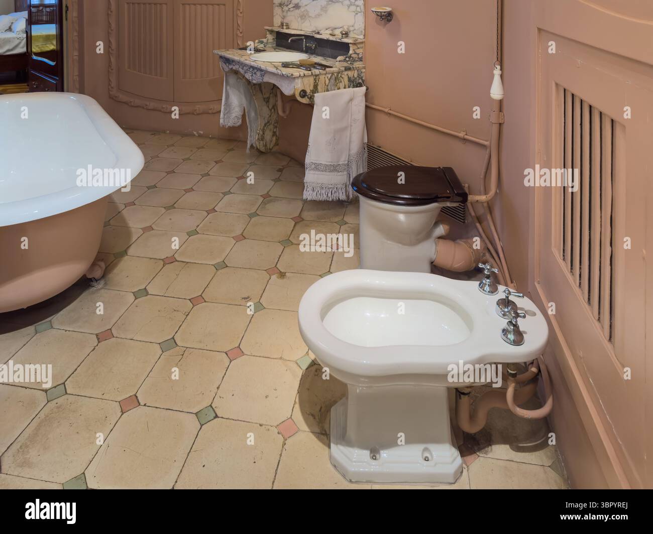 A bathroom from the early 20th century, with a bidet and other period ...