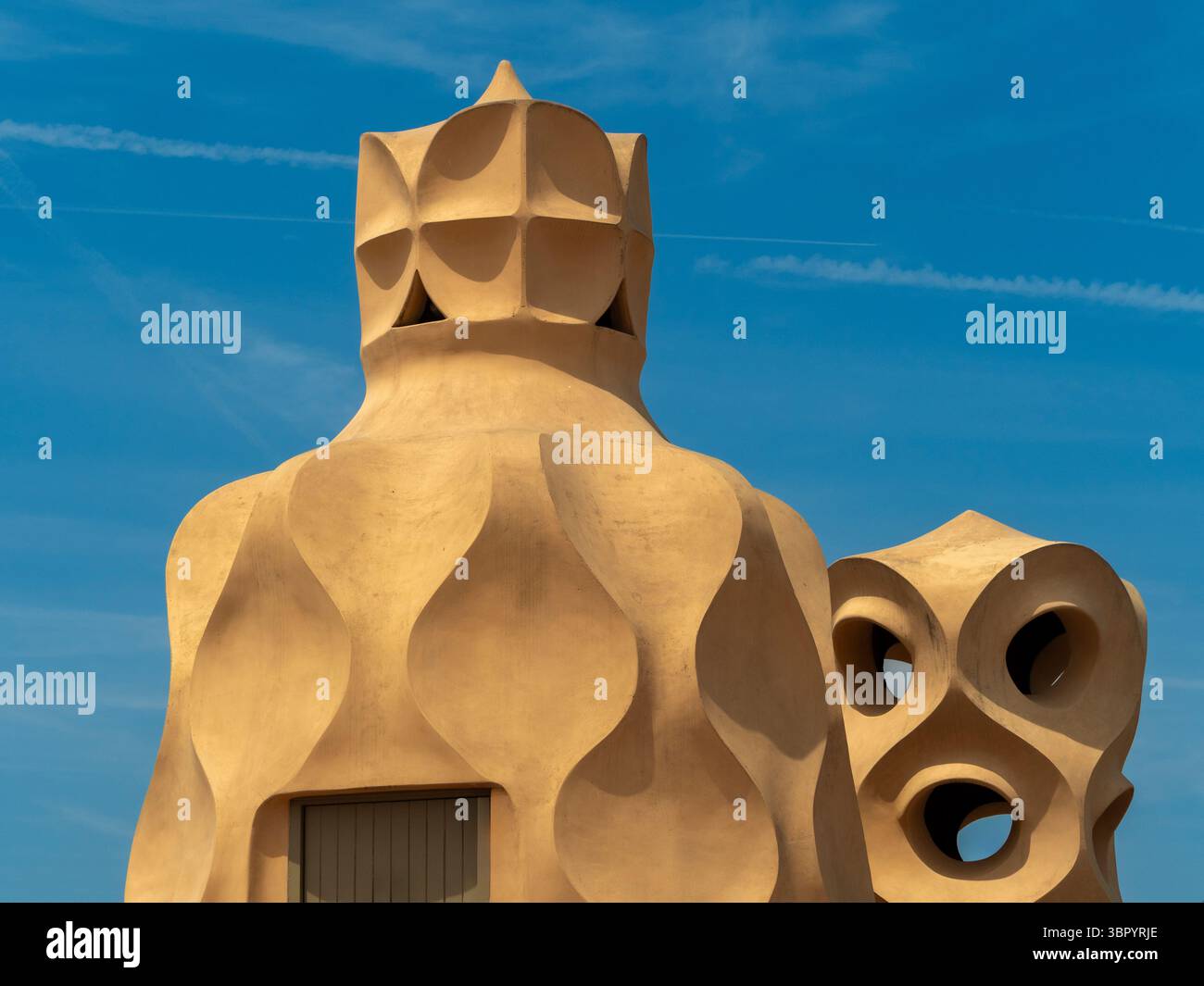 A sculptural ventilation tower and stairwell exit against a blue sky on ...