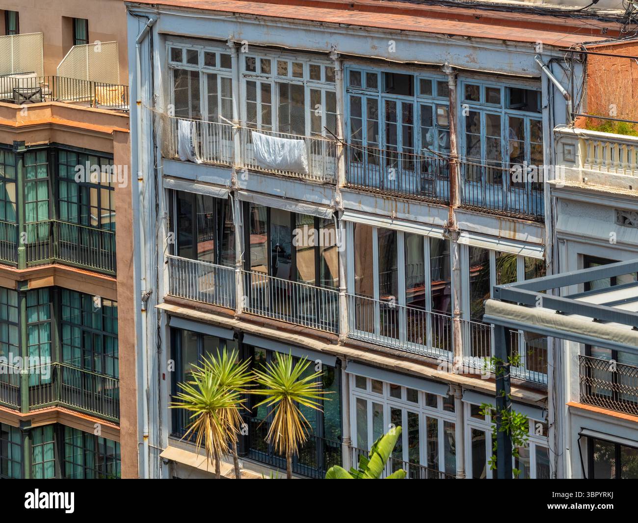 An old residential building with enclosed glass balconies, known as ...