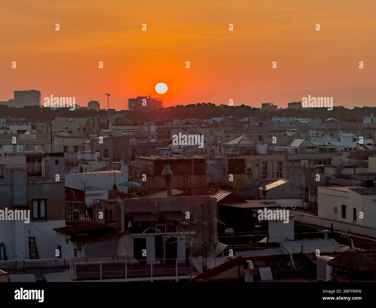 A beautiful, hazy orange sunrise over the rooftops of Barcelona, Spain ...