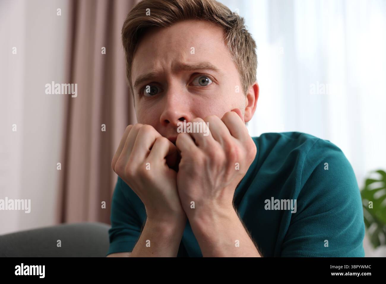 Scared man suffering from paranoia at home Stock Photo - Alamy