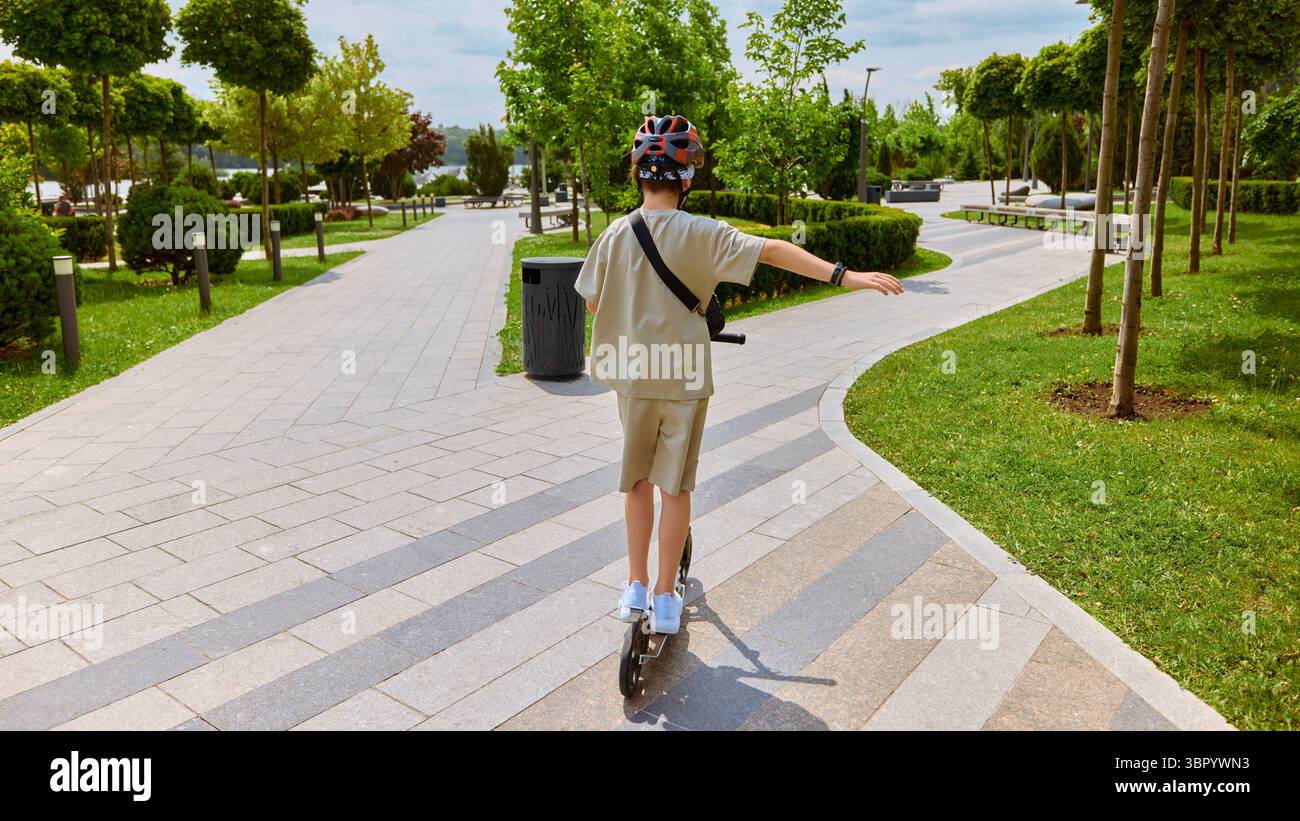 Kid driver. Boy on a scooter in a sunny park with a safety helmet Stock ...
