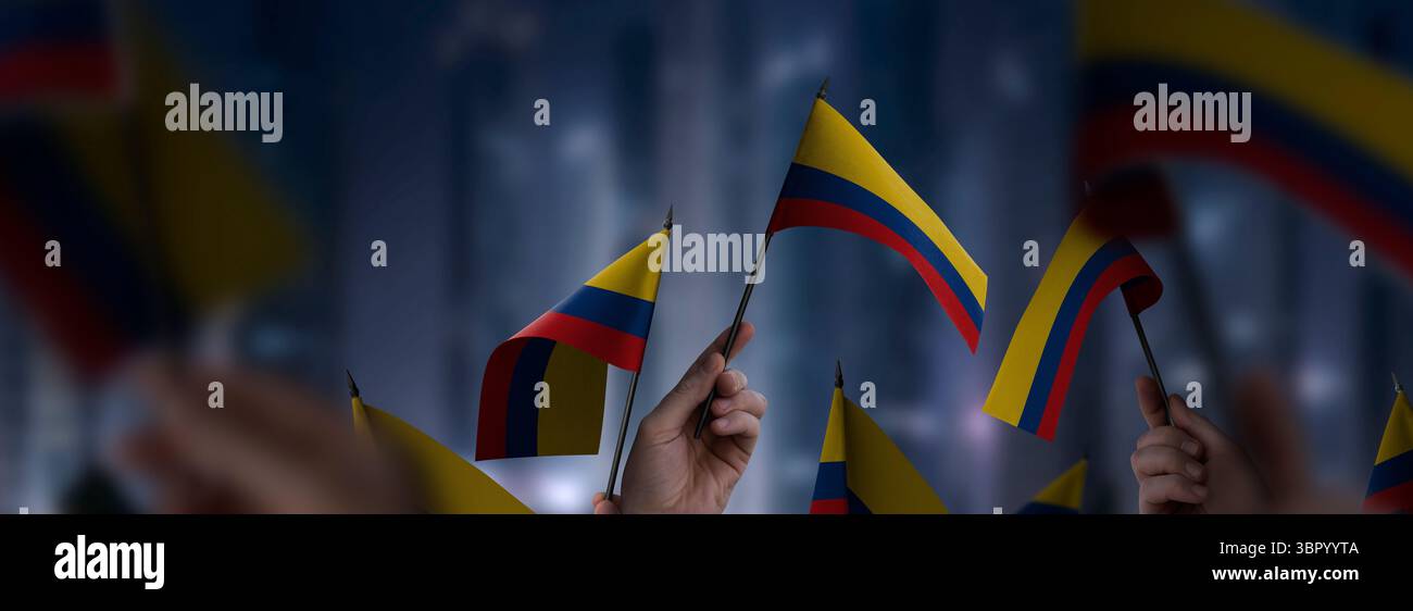 Colombia flags in their hands on a blurred urban background Stock Photo ...