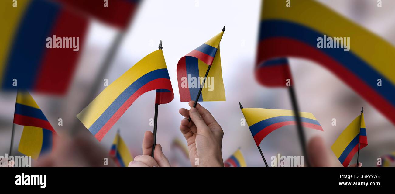Colombia flags in their hands on a blurred urban background Stock Photo ...