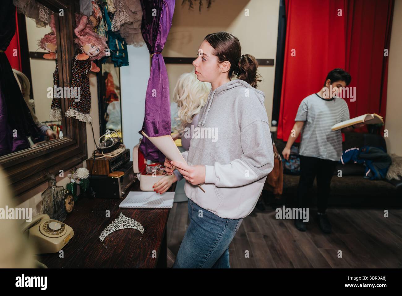 Young actors rehearsing lines backstage in a theater dressing room ...