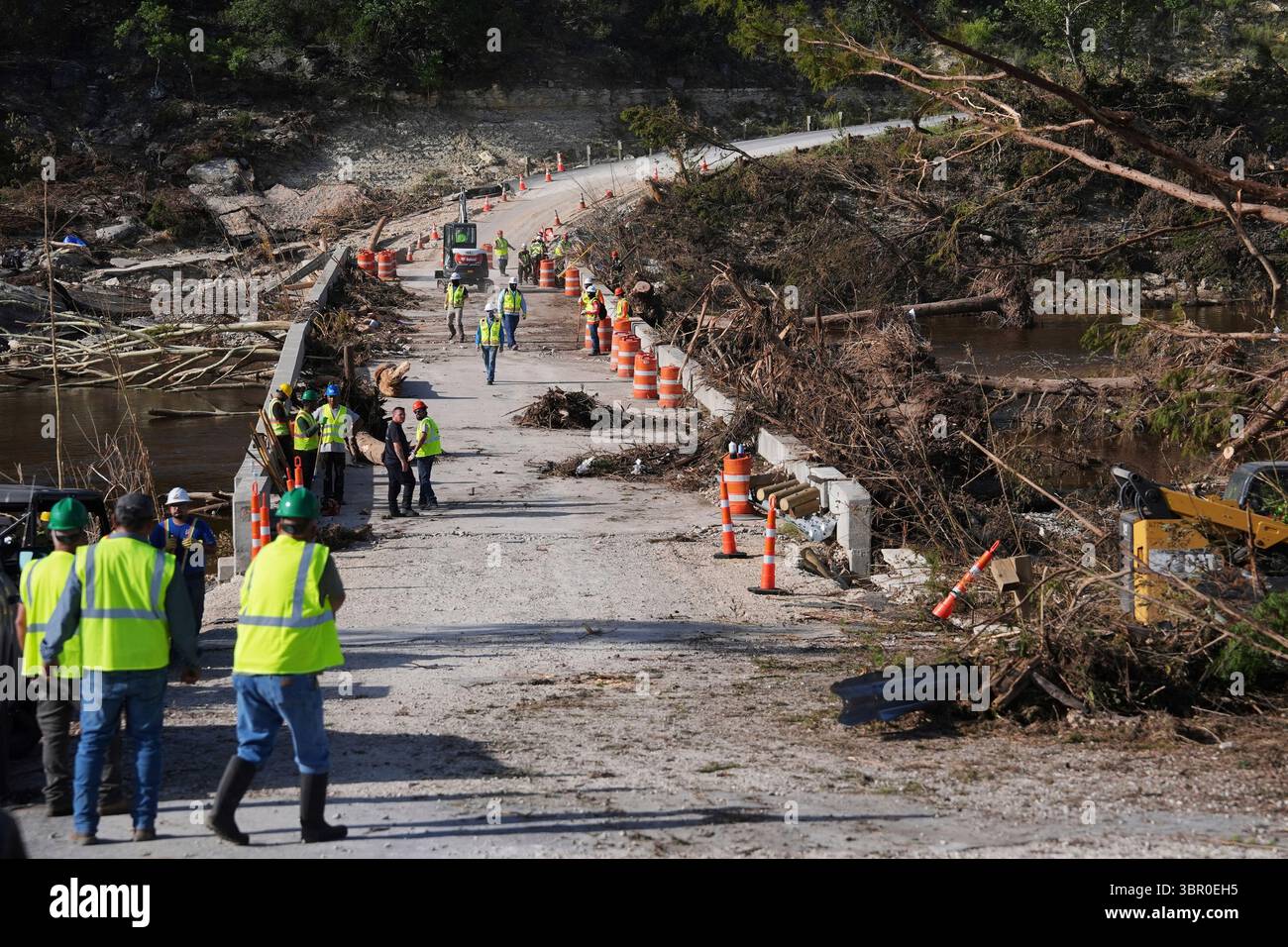 Crews work on the Cade Loop Bridge to clear debris after flooding along ...