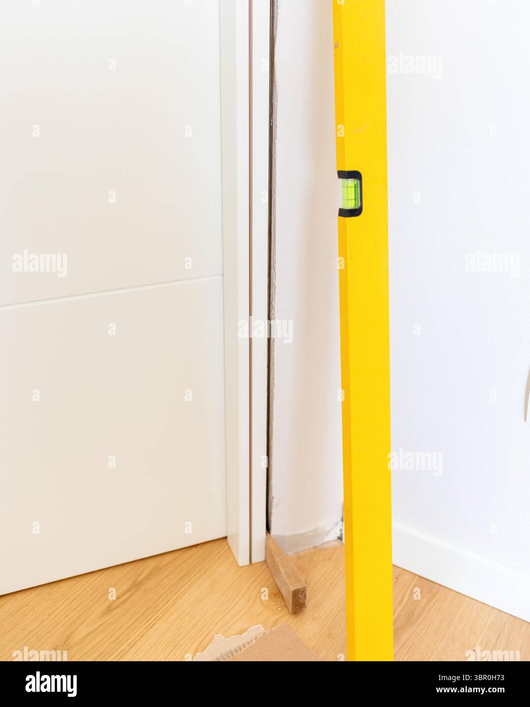 Yellow spirit level resting near door frame during installation, with a ...