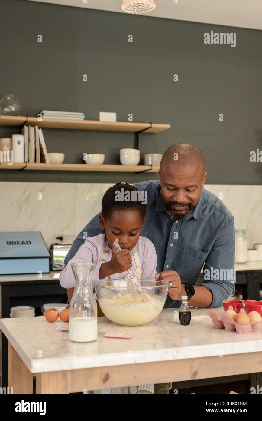 African American father and daughter preparing batter at marble island ...