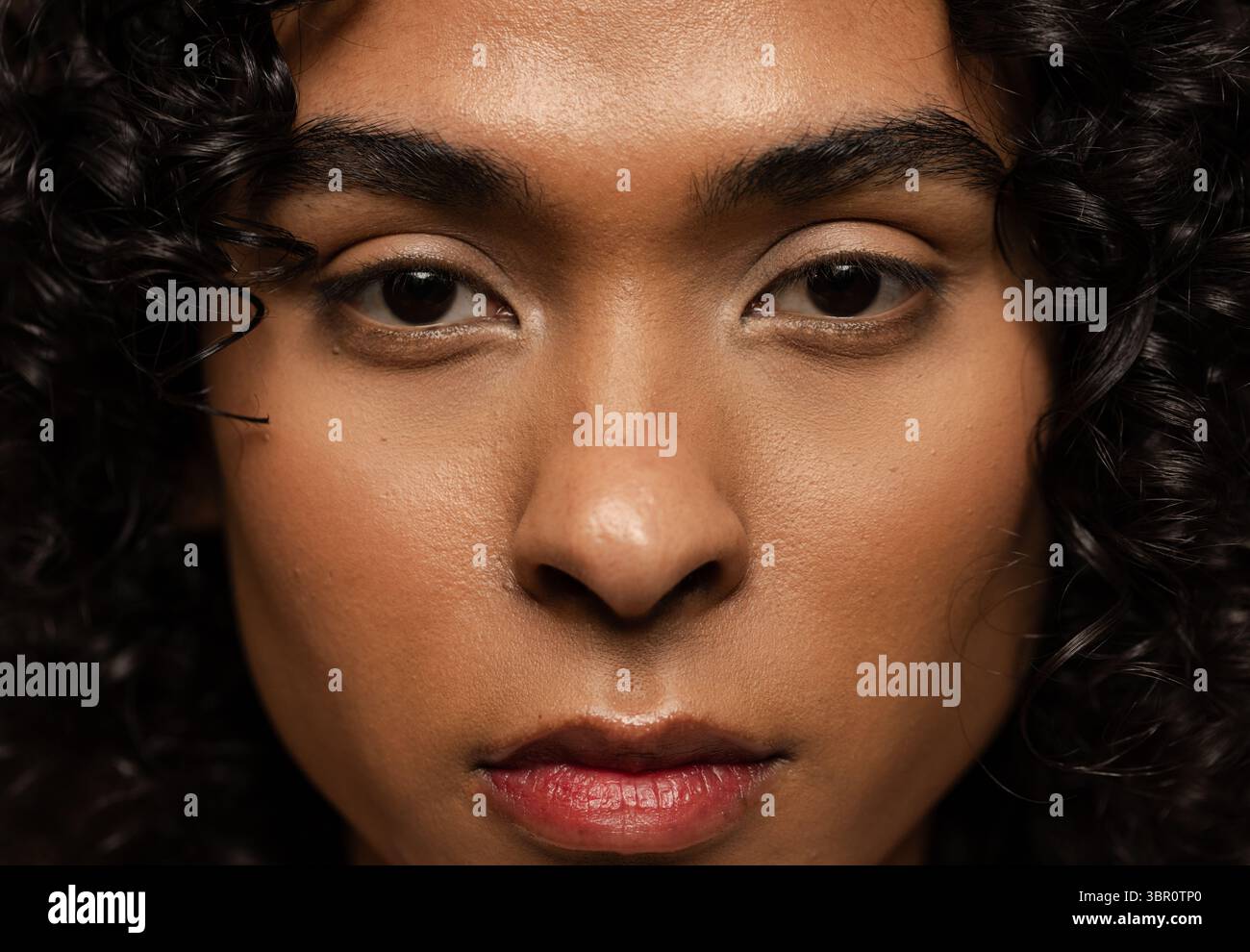 Non-binary person posing under soft directional lighting in portrait ...
