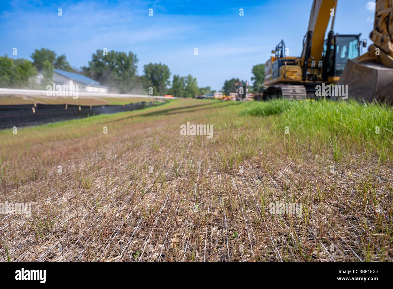 Woven straw mat used for stormwater erosion control with grass growing ...