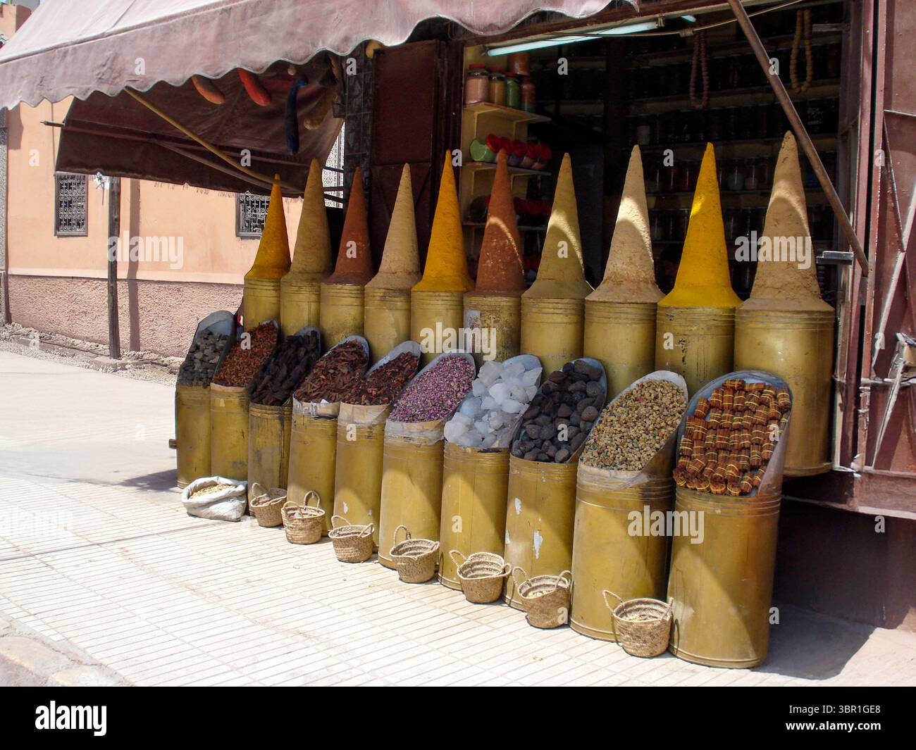 Outdoor Moroccan market stall selling vibrant spices in tall conical ...