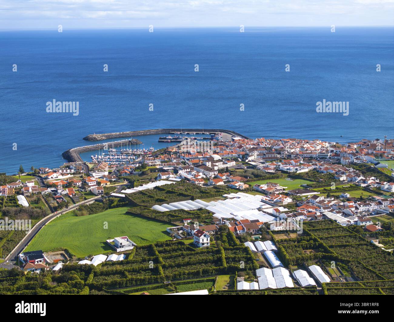Aerial view of a coastal town nestled between the deep blue ocean and ...