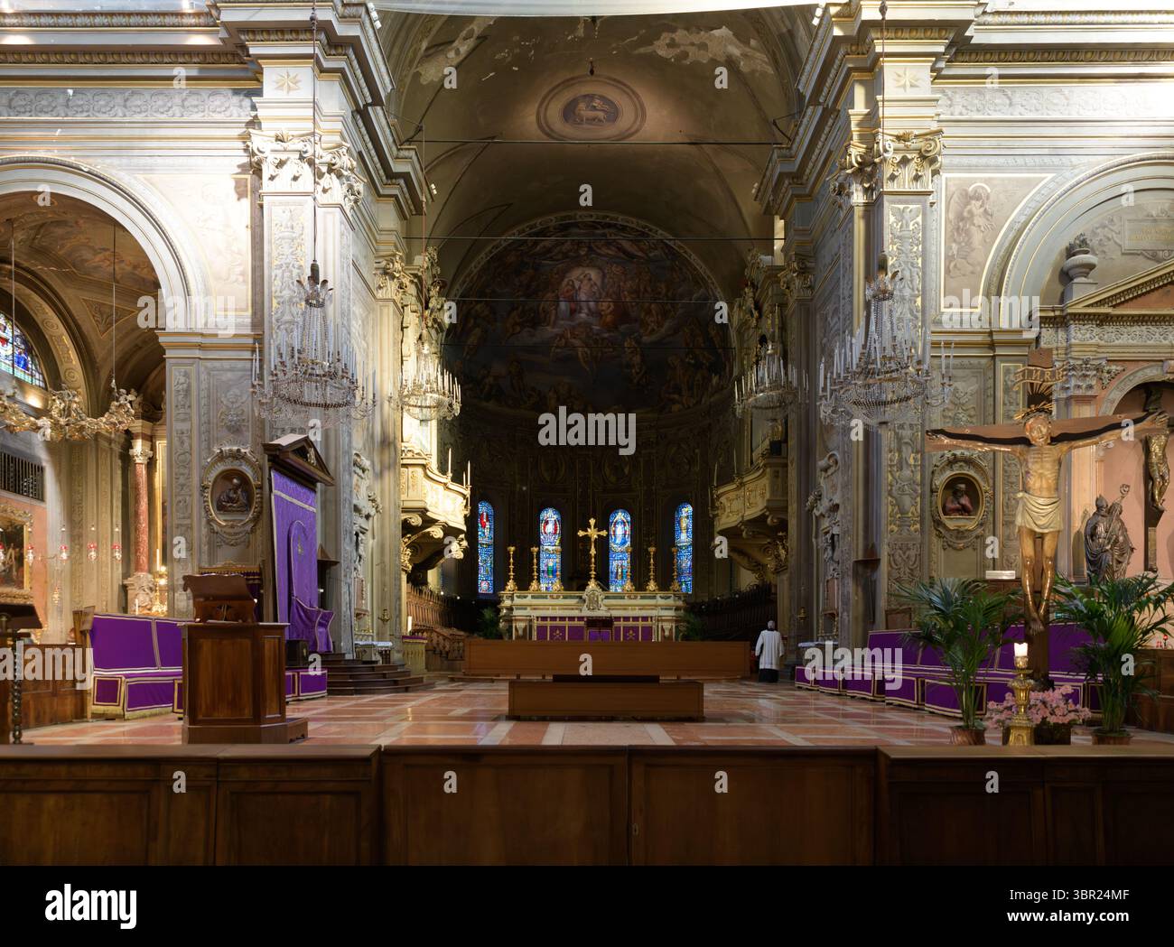 Baroque church interior with frescoed apse, chandeliers, pews, and ...