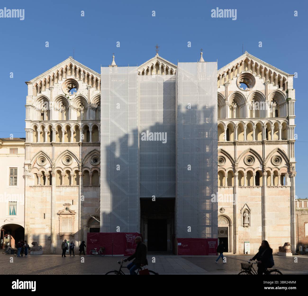 Romanesque and Gothic facade of Ferrara Cathedral with sculpted portal ...