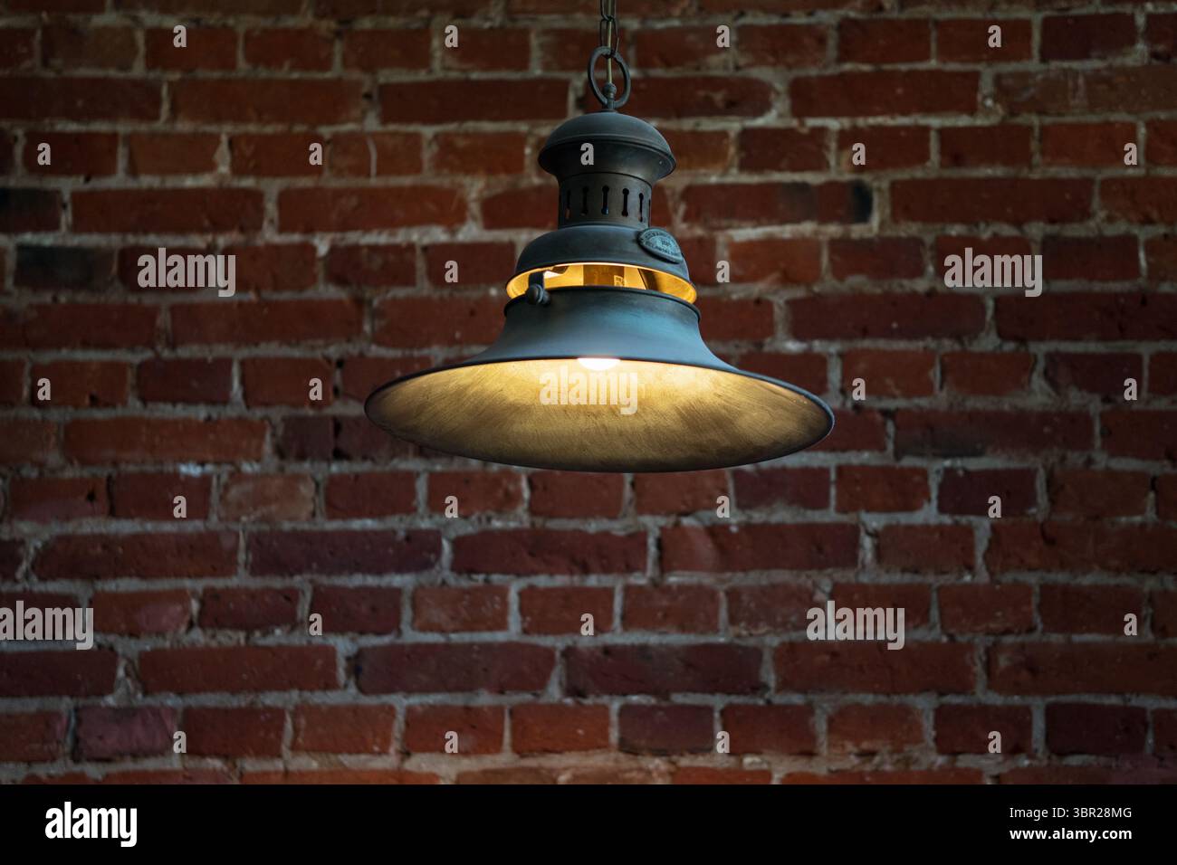 Retro-style ceiling lamp hanging on a metal chain, casting warm light ...