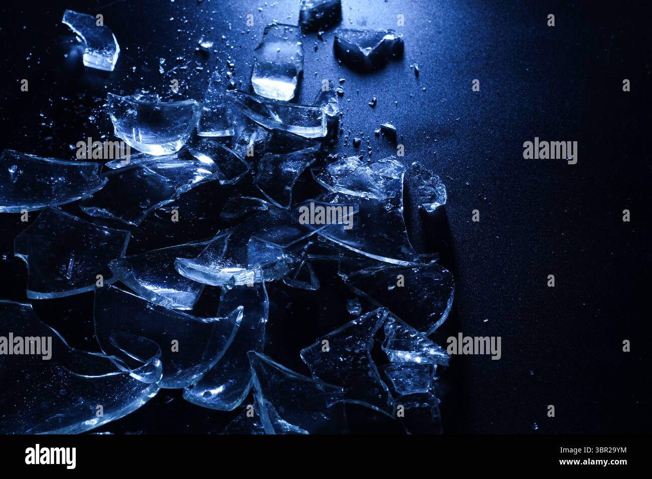 Broken Glass Shards on Dark Surface with Cold Lighting Stock Photo - Alamy