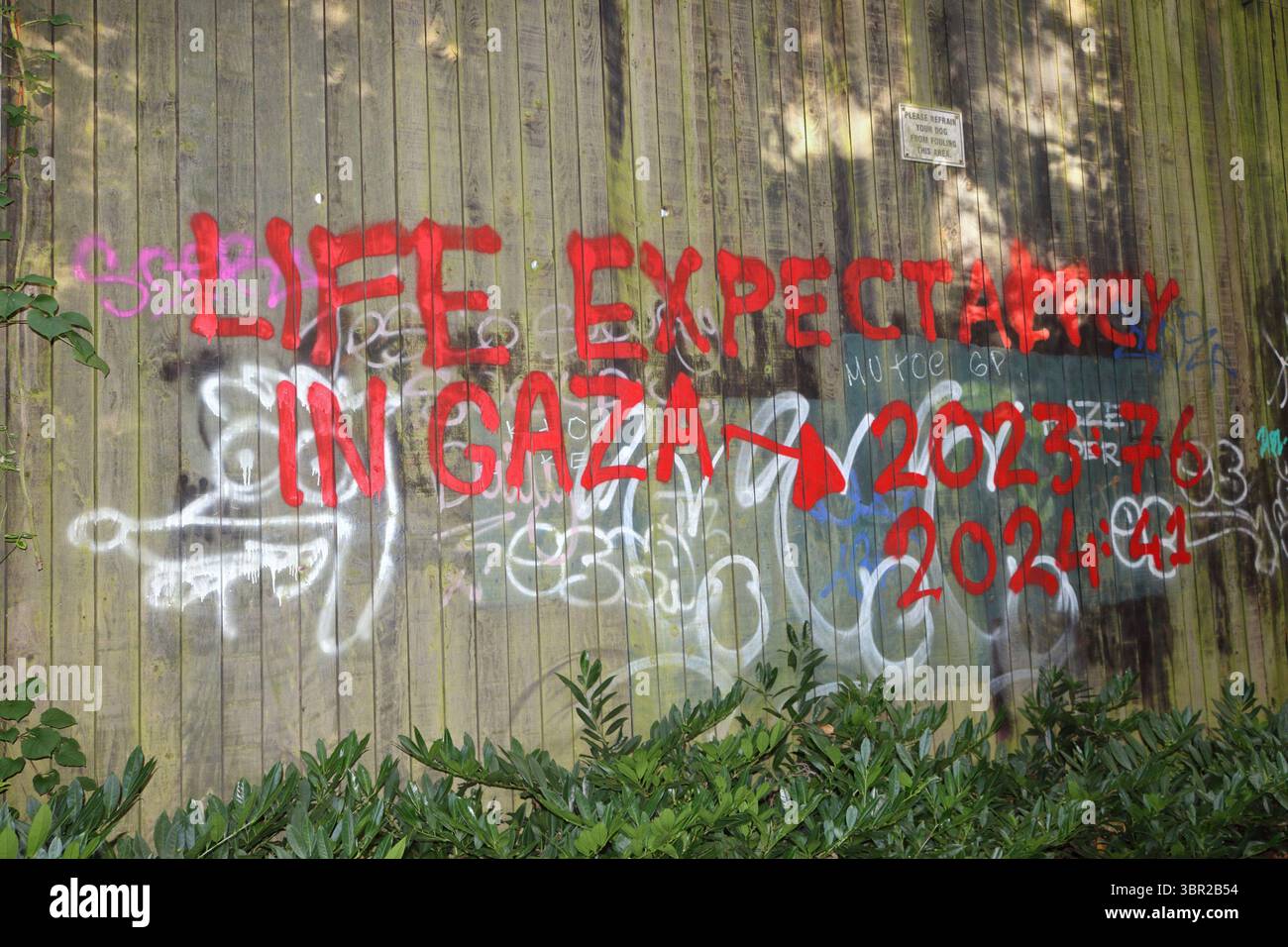 Graffiti painted on a wall, in red paint. Life expectancy in Gaza 2023 ...
