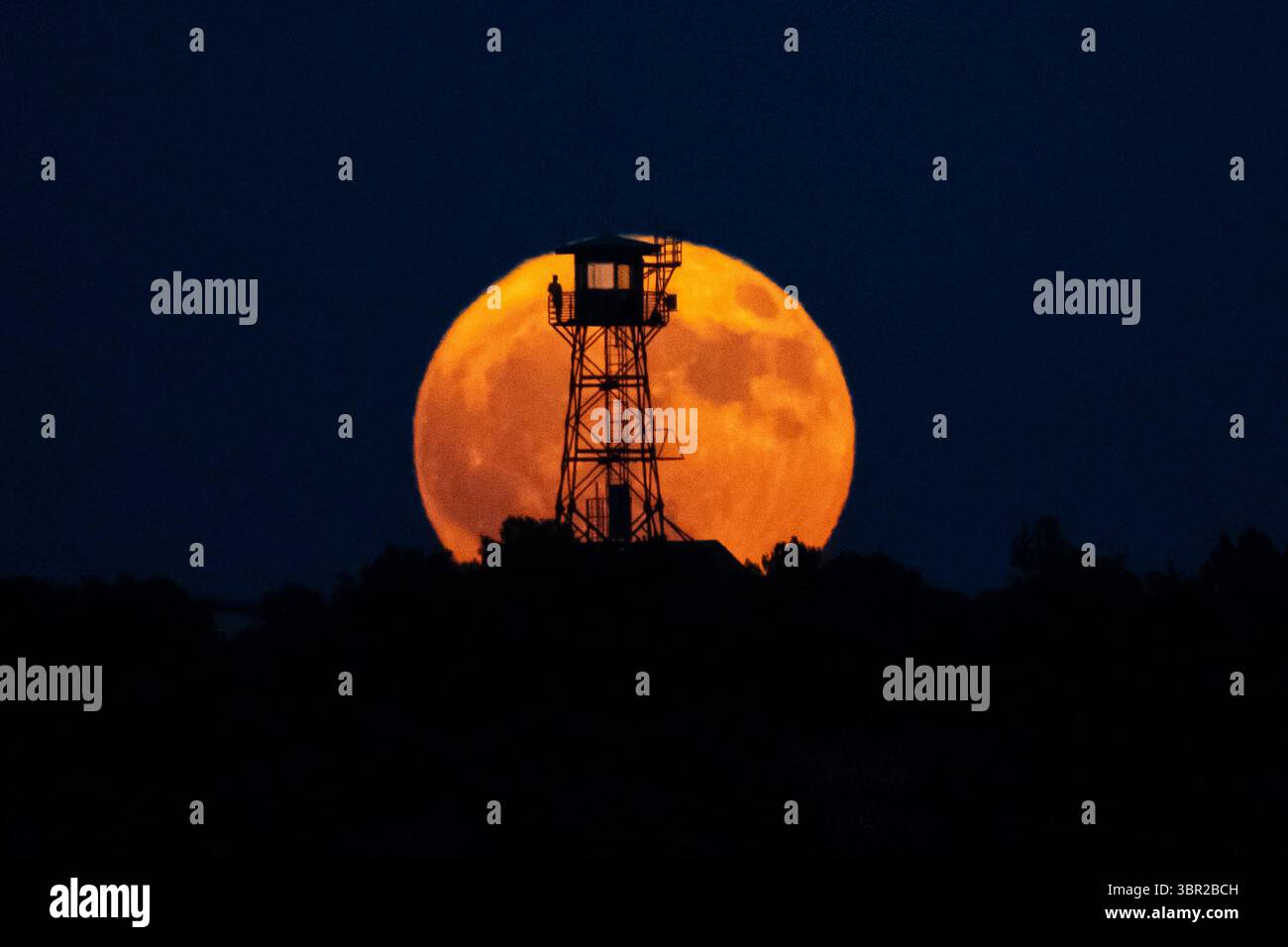 Madrid, Spain. 10th July, 2025. A fire lookout watches the moonrise of ...