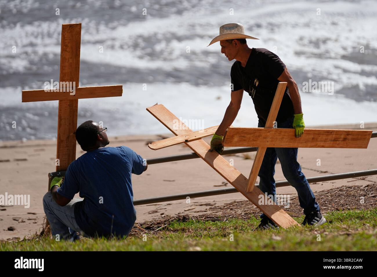 Raymond Simmons, left, and Roberto Marquez place crosses along the ...