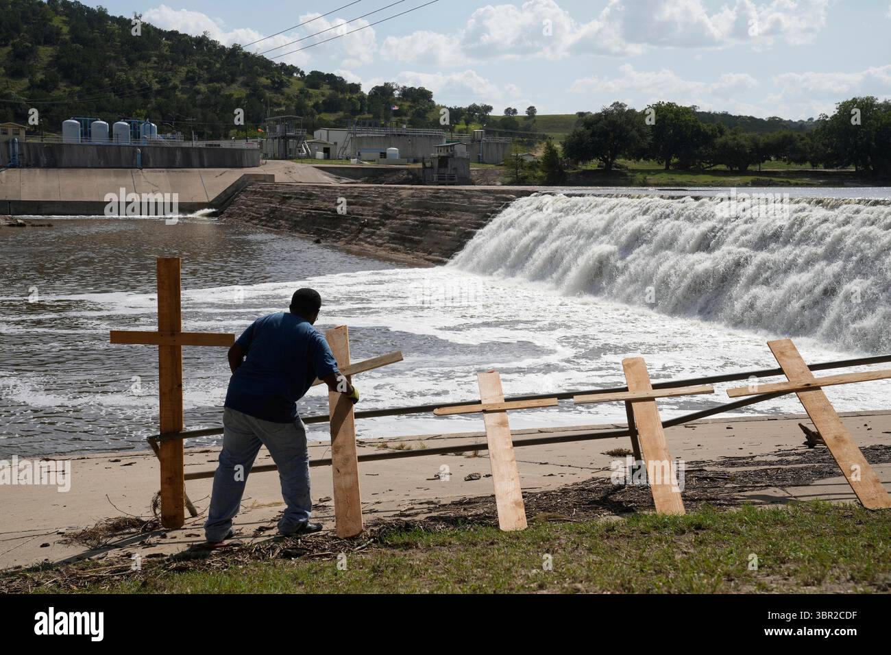 Raymond Simmons puts up crosses at a memorial along the Guadalupe River ...
