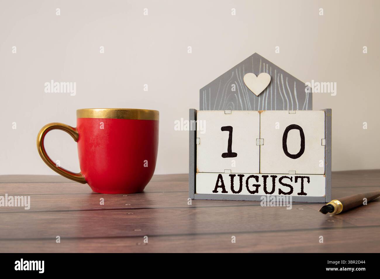 Wooden block calendar with the date August 10 and spikelets of wheat on ...
