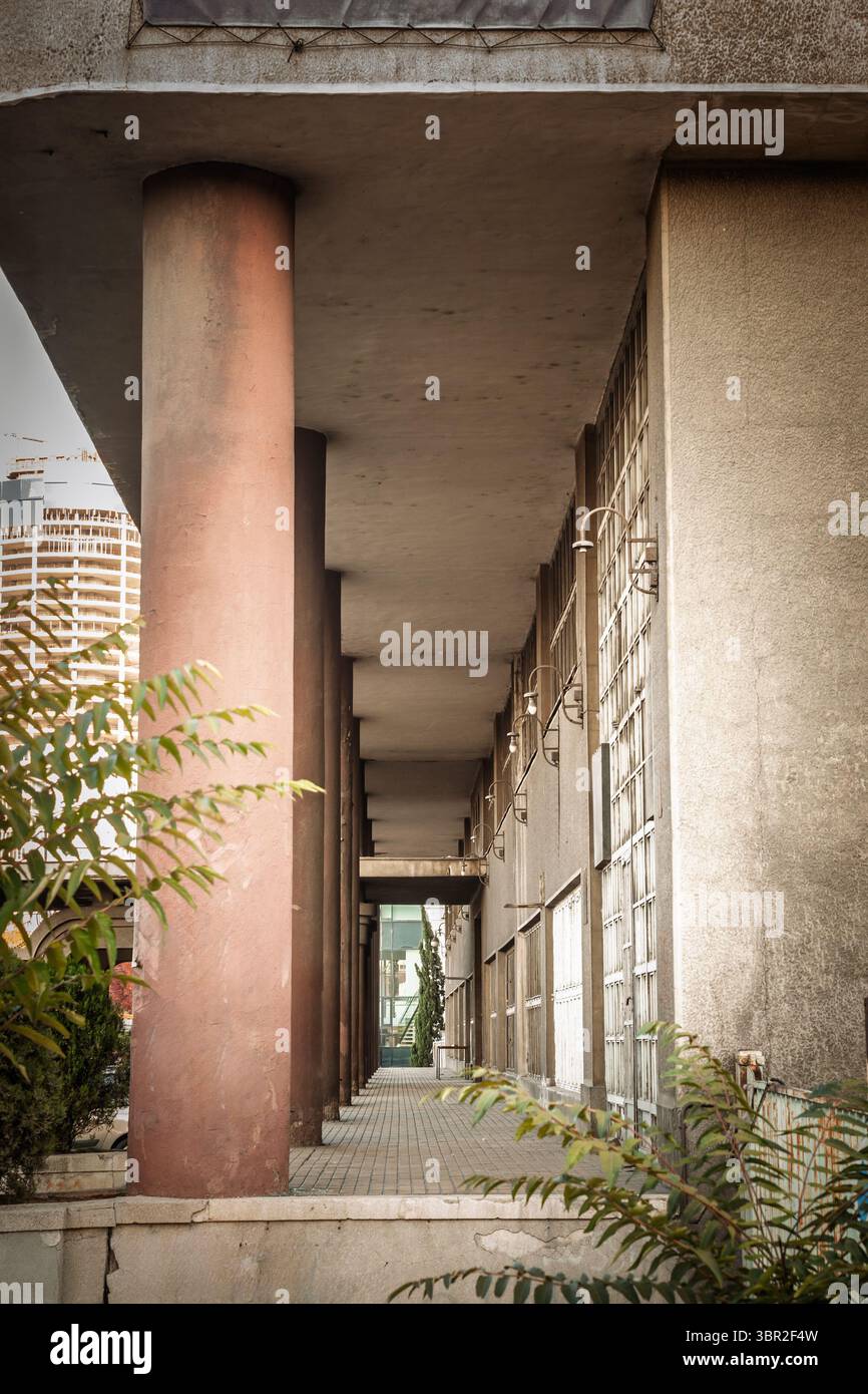 Low angle perspective down a long shaded outdoor corridor with massive ...