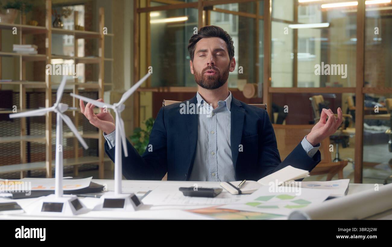 Engineer meditating business wind turbine project models stress relief ...