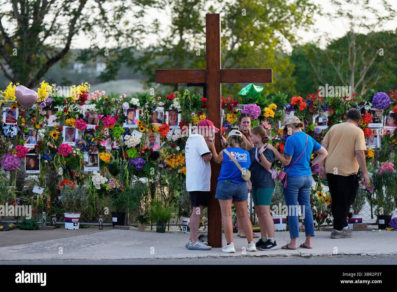 Dan Beazley, left, holds a large cross as he prays with visitors at a ...