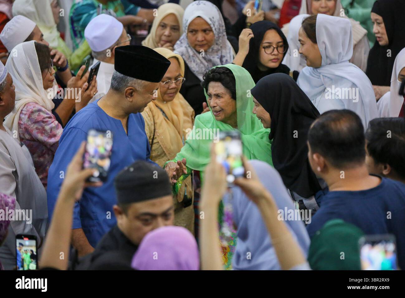 Supporters crowd around Tun Siti Hasmah hoping to greet and shake hands ...