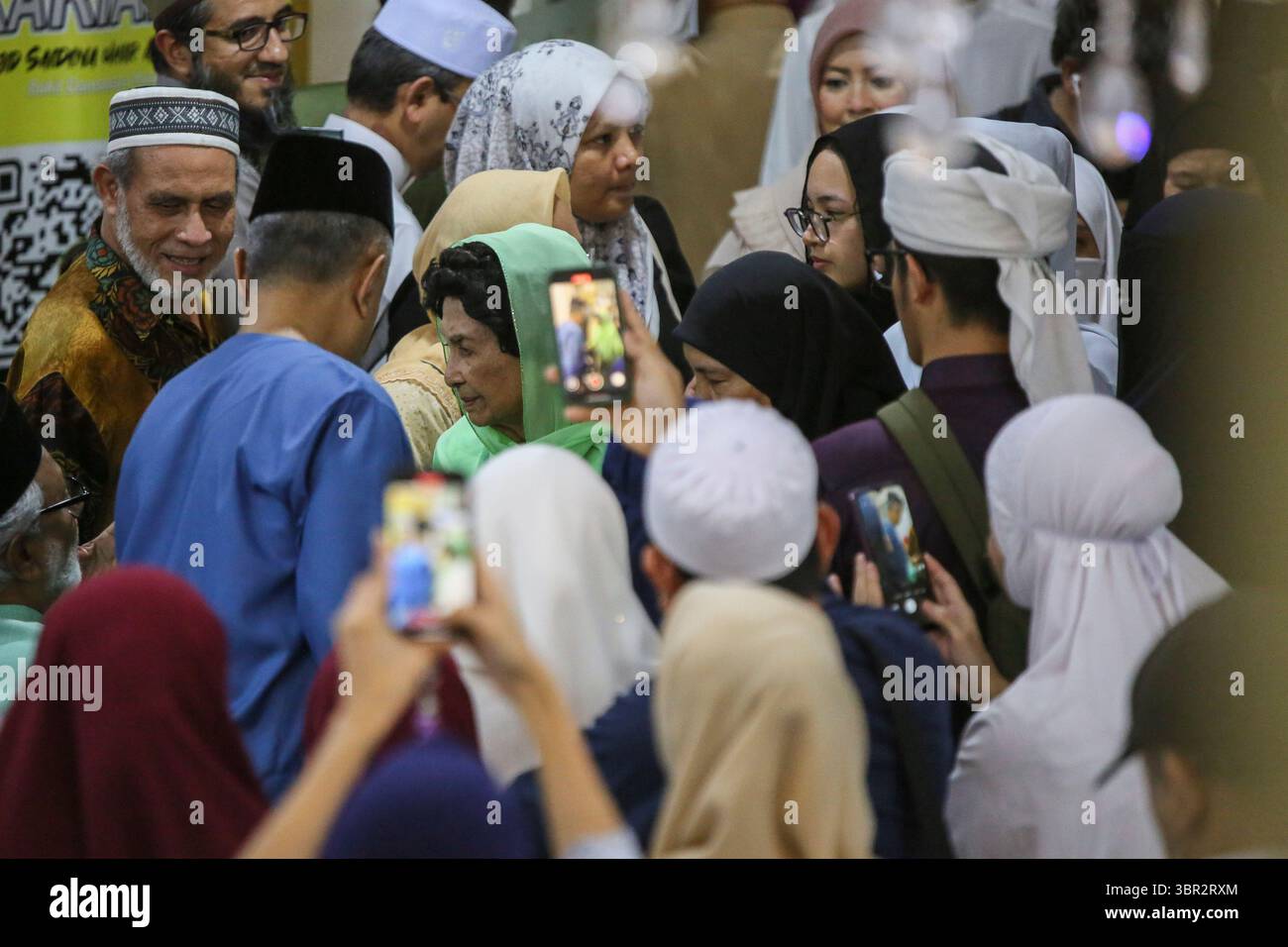 Supporters crowd around Tun Siti Hasmah hoping to greet and shake hands ...