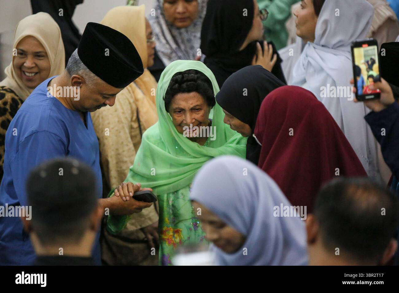 Supporters crowd around Tun Siti Hasmah hoping to greet and shake hands ...