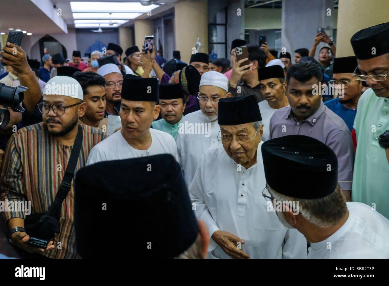 Supporters crowd around Tun Mahathir Mohamad, hoping to greet and shake ...