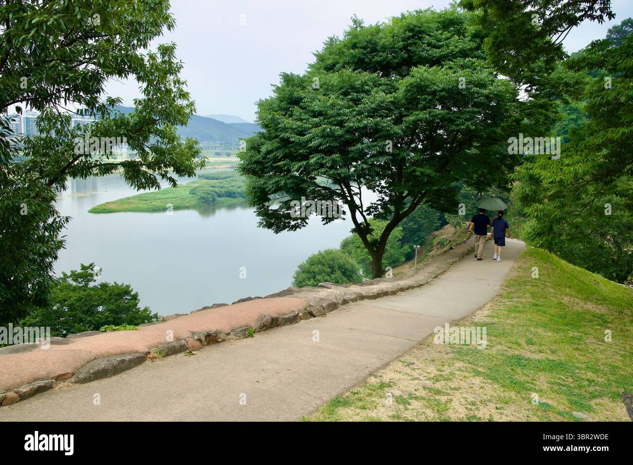 Gongju, South Korea - June 13th 2025: A couple walks along a shaded ...