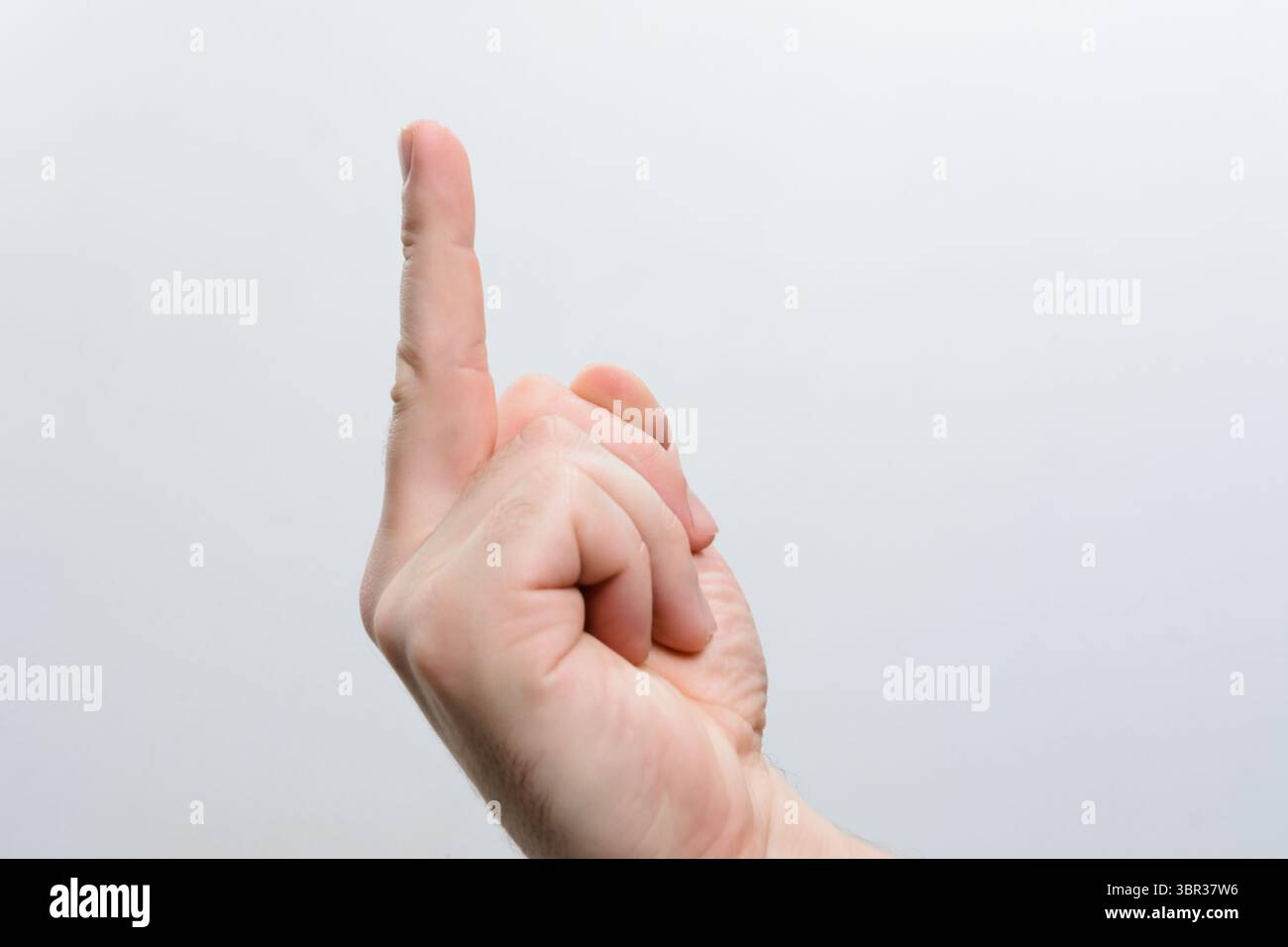 A close-up of a hand making a gesture against a simple, neutral ...